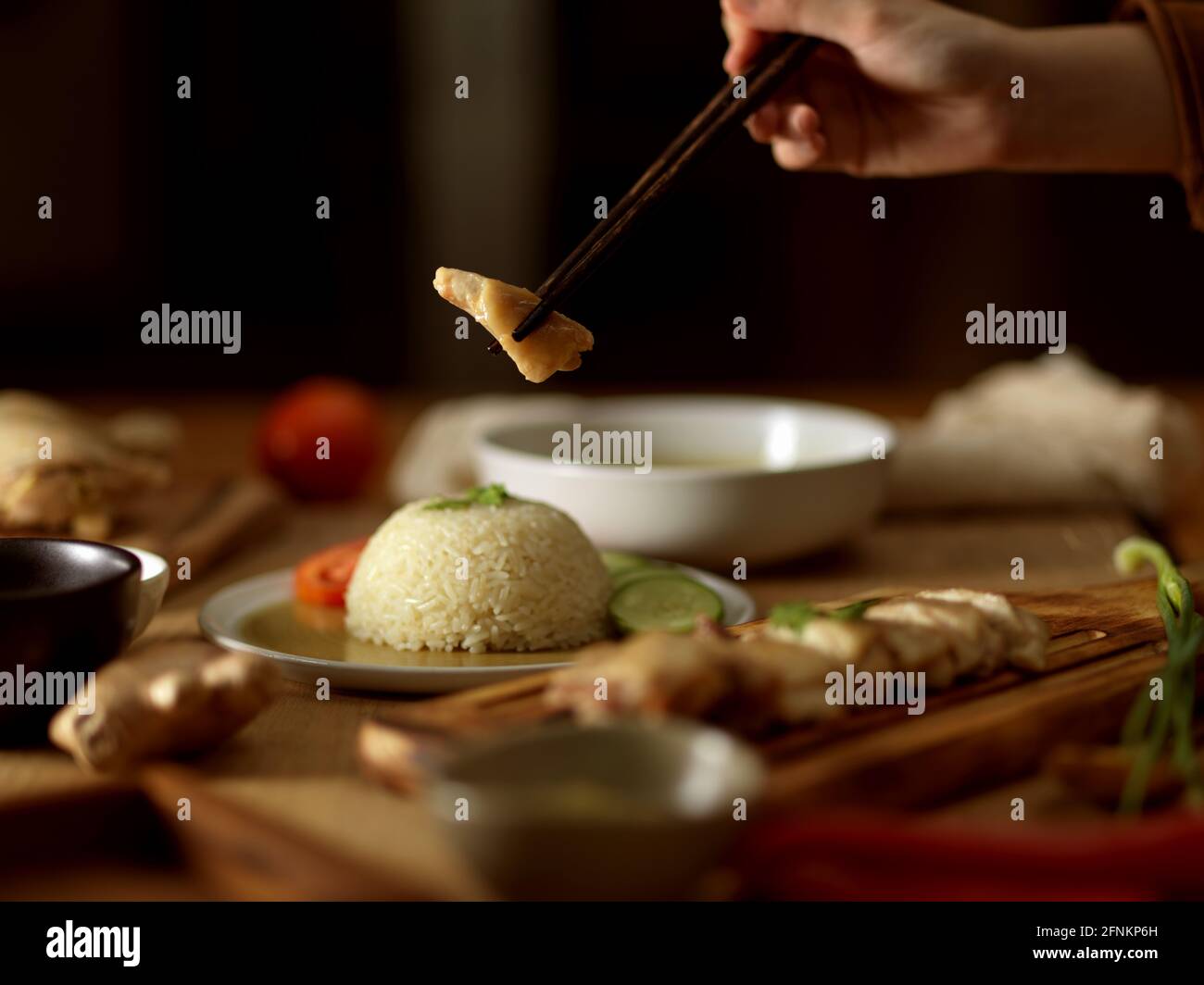 Cropped shot of woman use chopsticks to grab chicken, Hainanese chicken ...