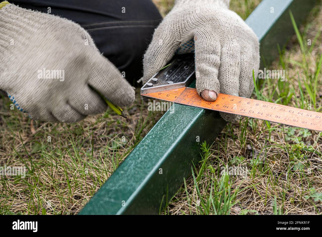 close-up of a male joiner measuring the incision with a ruler and ...