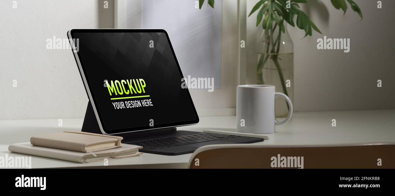 Side view of digital tablet with keyboard and stationery on modern ...