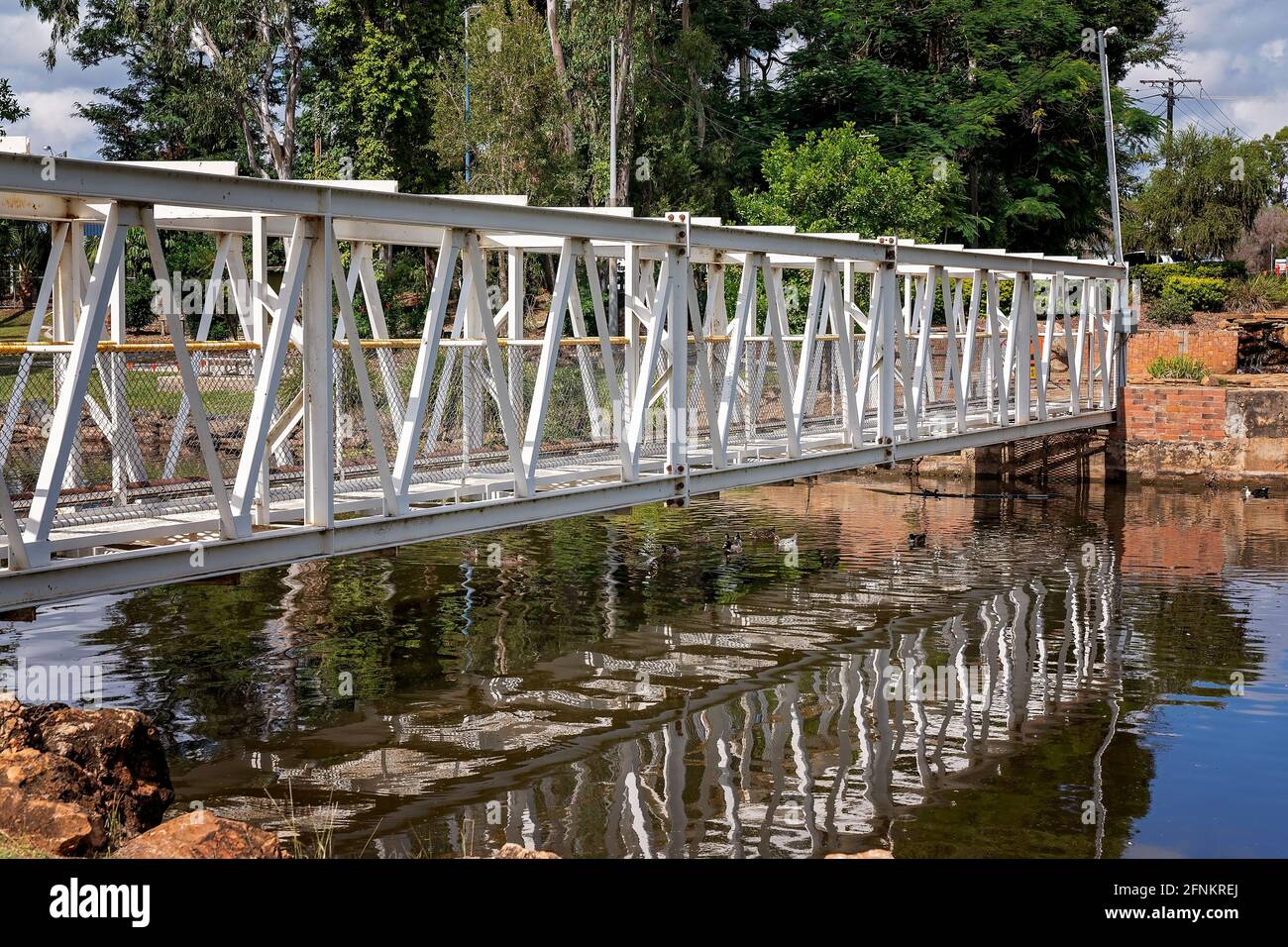 A walkway bridge over a lagoon with water reflections Stock Photo - Alamy