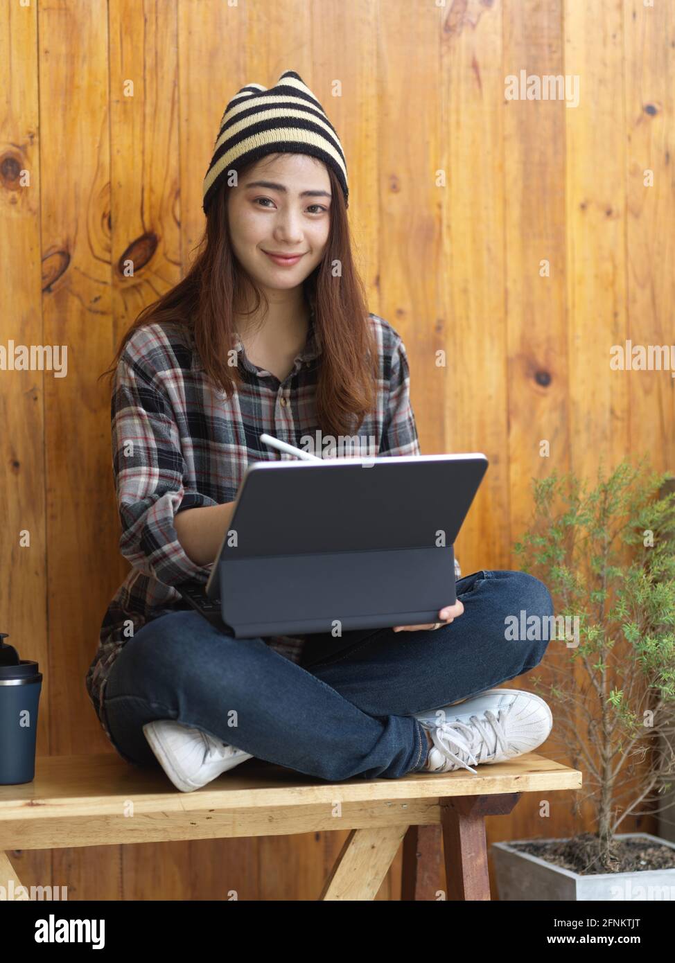 Portrait of female teenager working with digital tablet on her lap ...