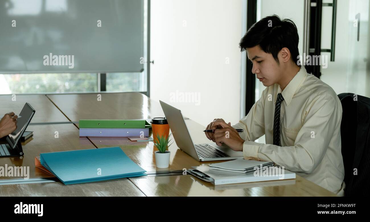 Male office worker browsing in laptop for necessary information, Young ...