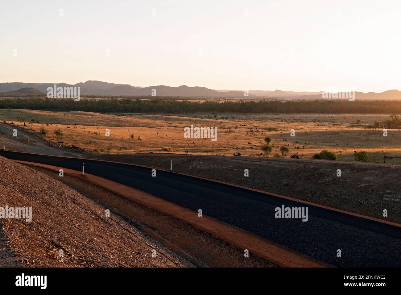 A country road with built up sides in outback Australia at sunset Stock ...