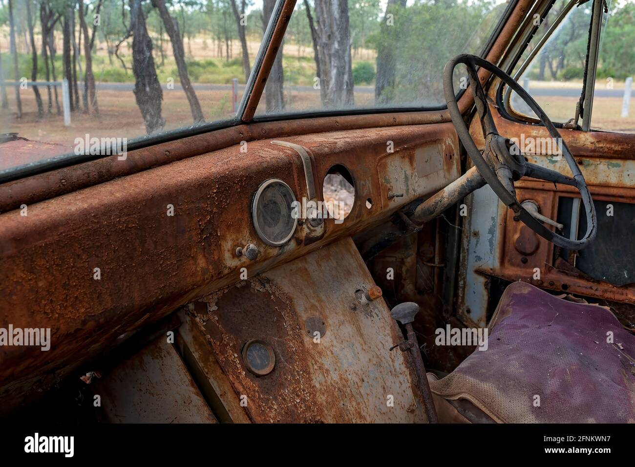 Interior showing dashboard, steering wheel and seat of rusted truck ...