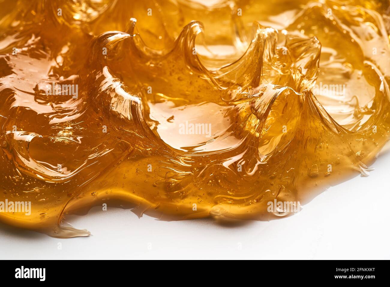 Transparent yellow smear of face cream or golden honey isolated on ...