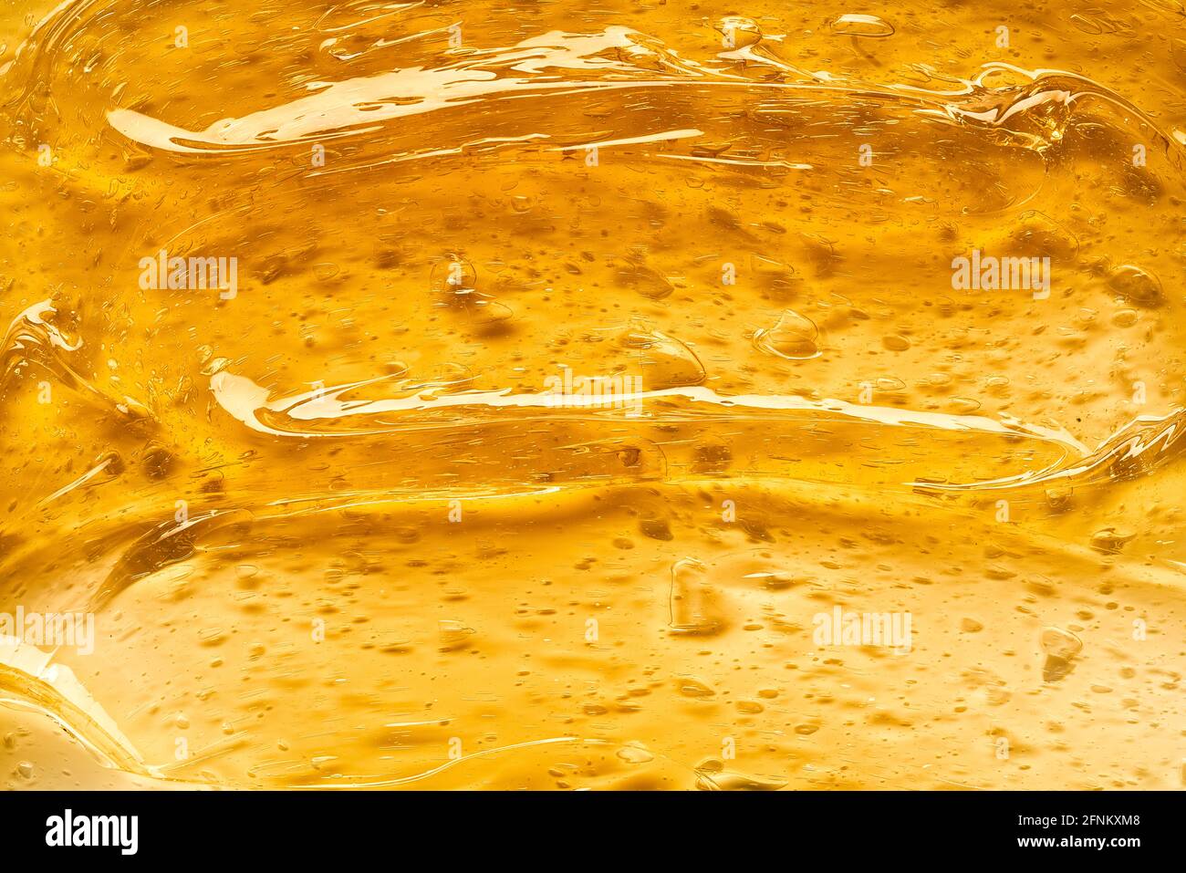 Transparent yellow smear of face cream or golden honey isolated on ...