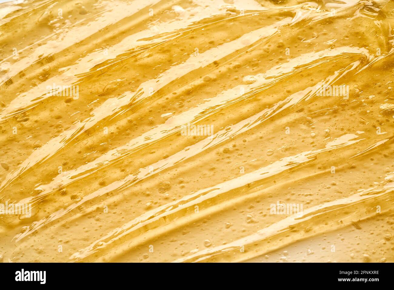 Transparent yellow smear of face cream or golden honey isolated on ...