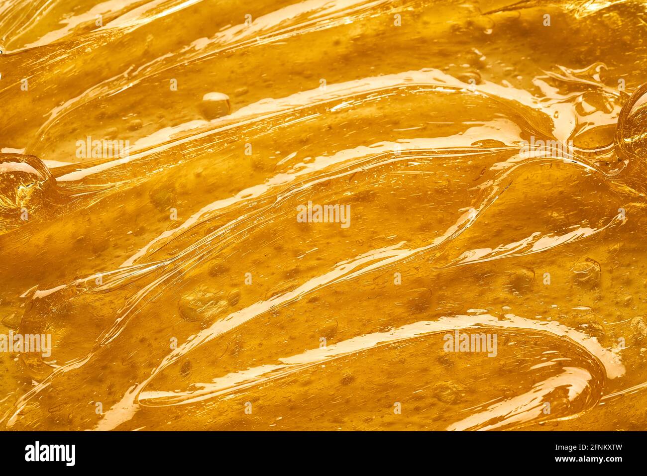 Transparent yellow smear of face cream or golden honey isolated on ...
