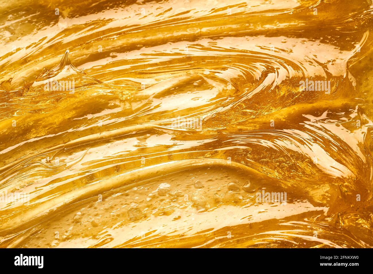 Transparent yellow smear of face cream or golden honey isolated on ...