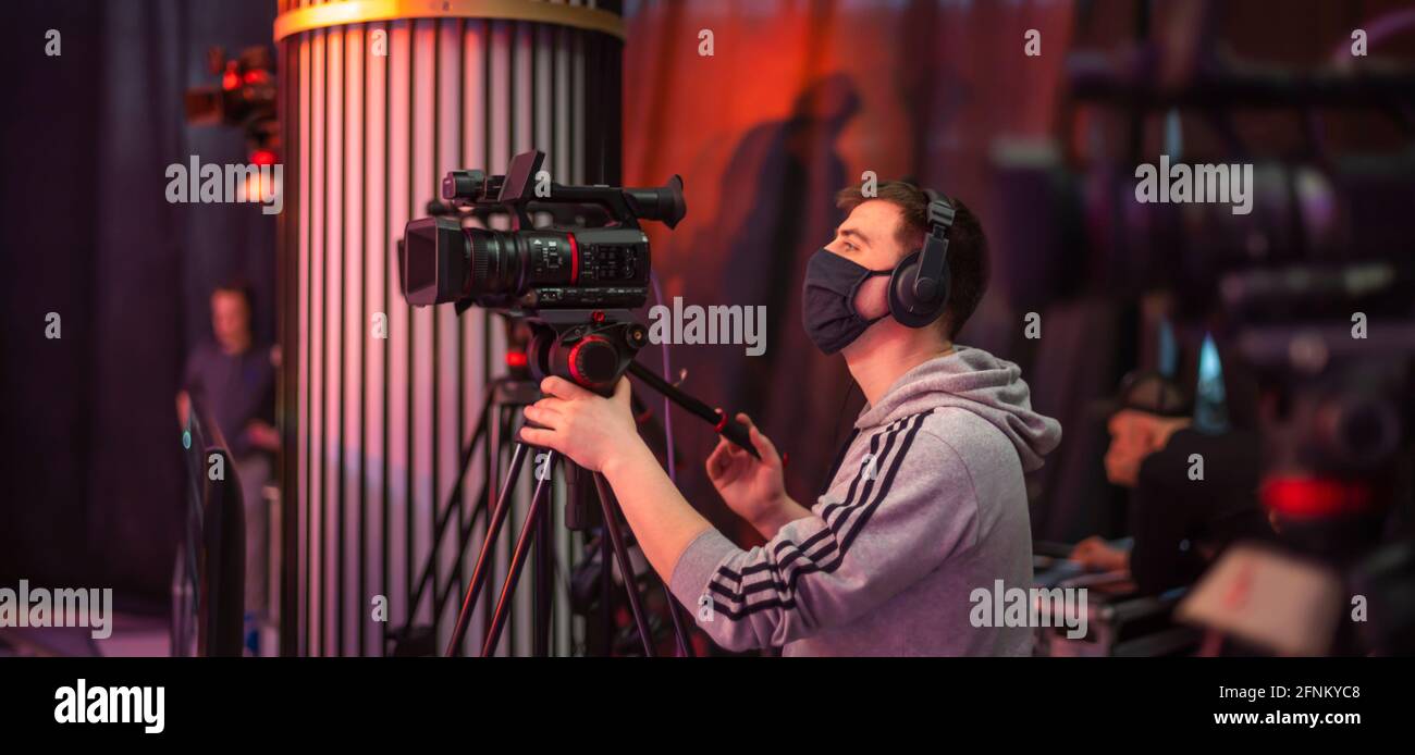 masked cameraman is filming a television show in the studio. TV Stock ...