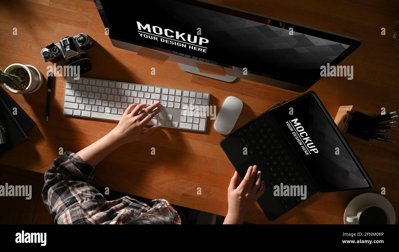 Overhead shot of female hand working with computer and laptop include ...