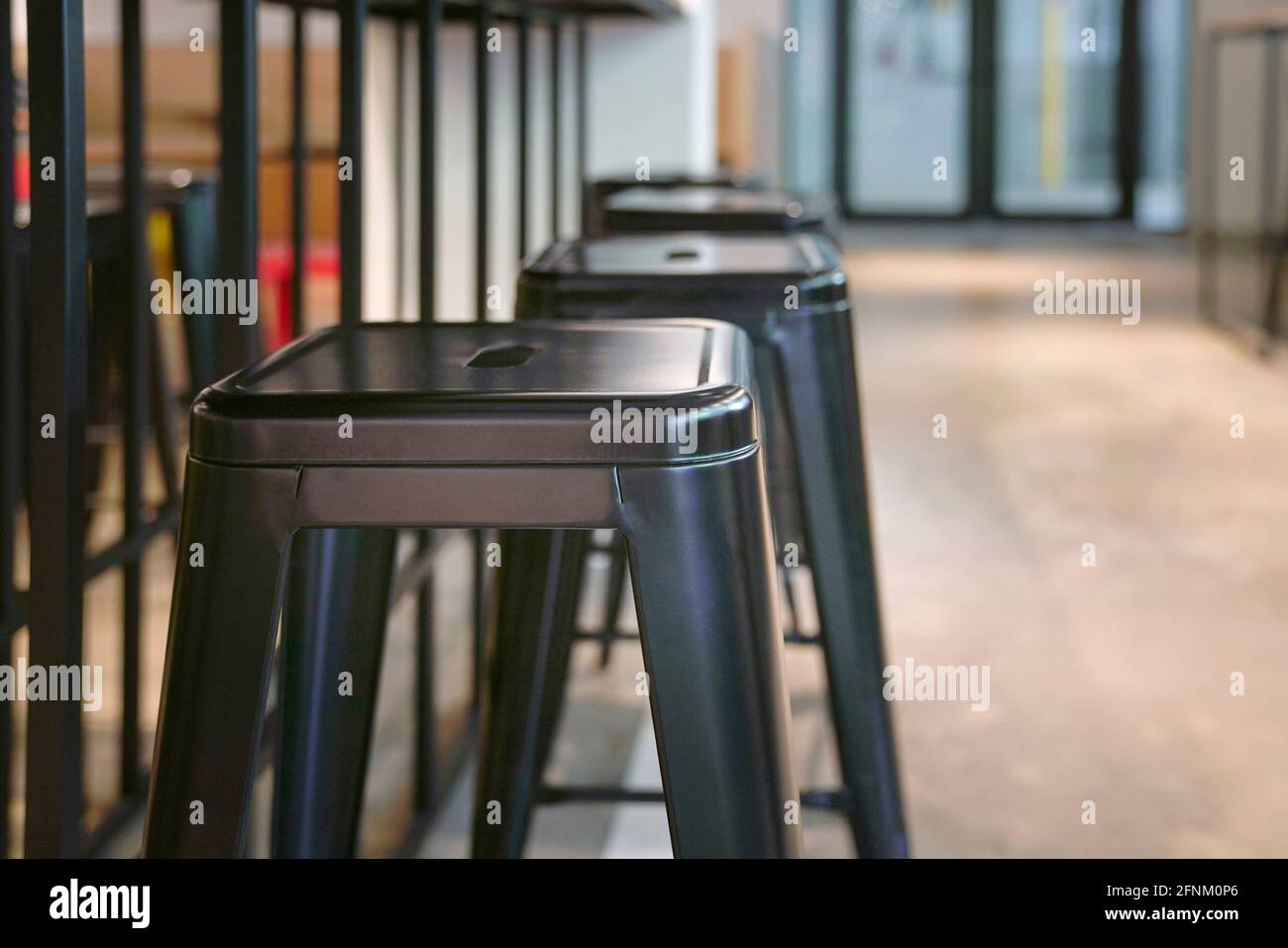 Close up of black metal stools in an empty restaurant Stock Photo - Alamy