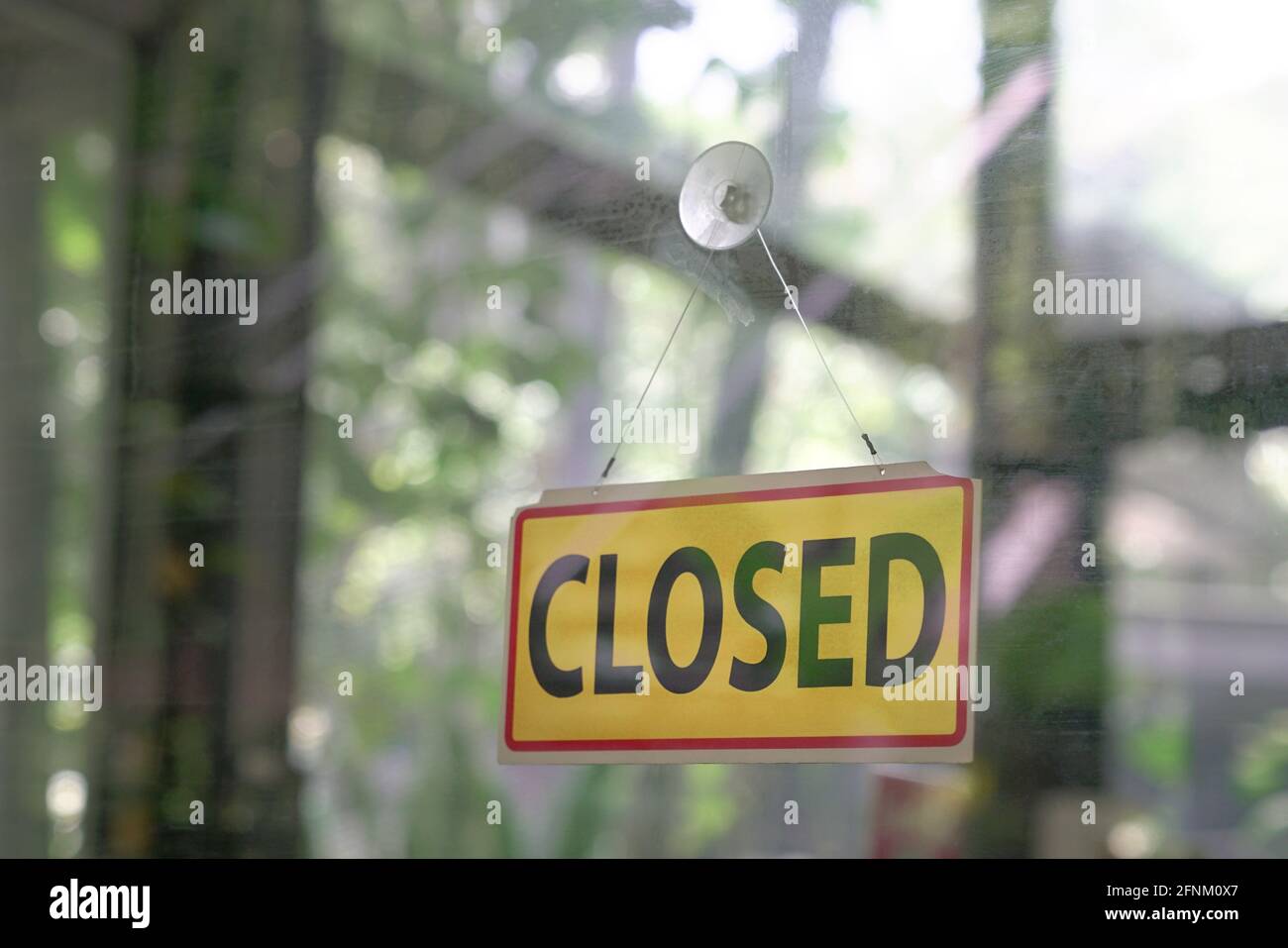 Closed signboard hanging on glass door of a restaurant. Copy space ...