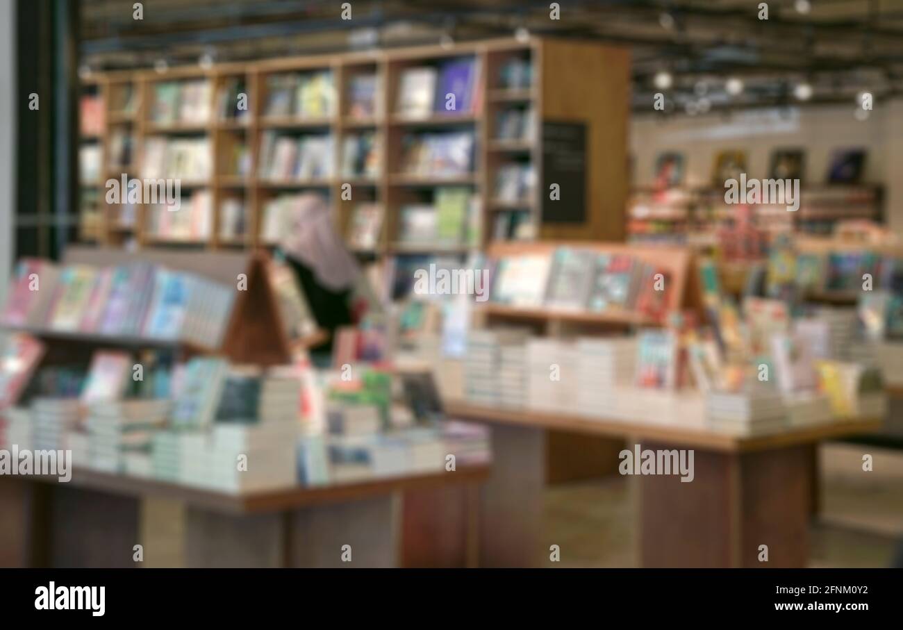 Bookstore with shopper with stack of books on display. Defocused Stock ...