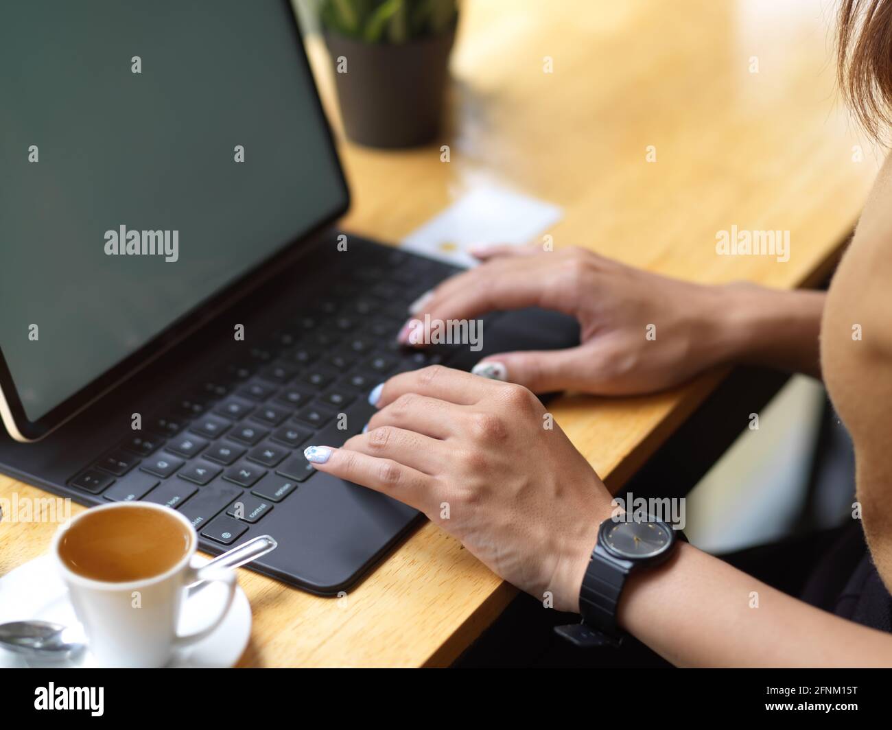 Side view of female hands typing on tablet keyboard while working in ...