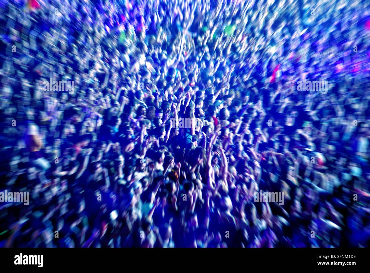 Zoom in effect on a blurred crowd partying at a music festival Stock ...