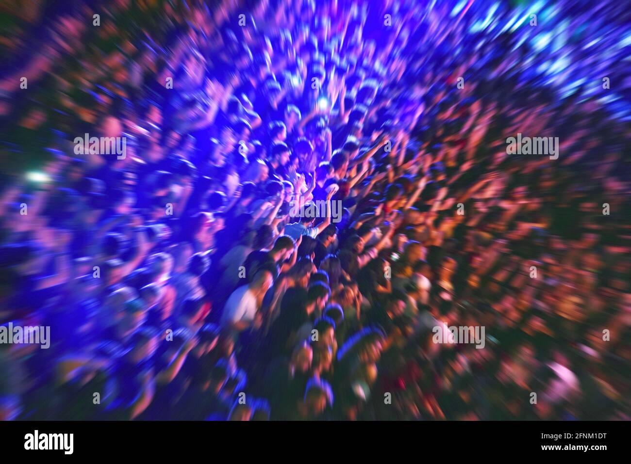 Zoom in effect on a blurred crowd partying at a music festival Stock ...