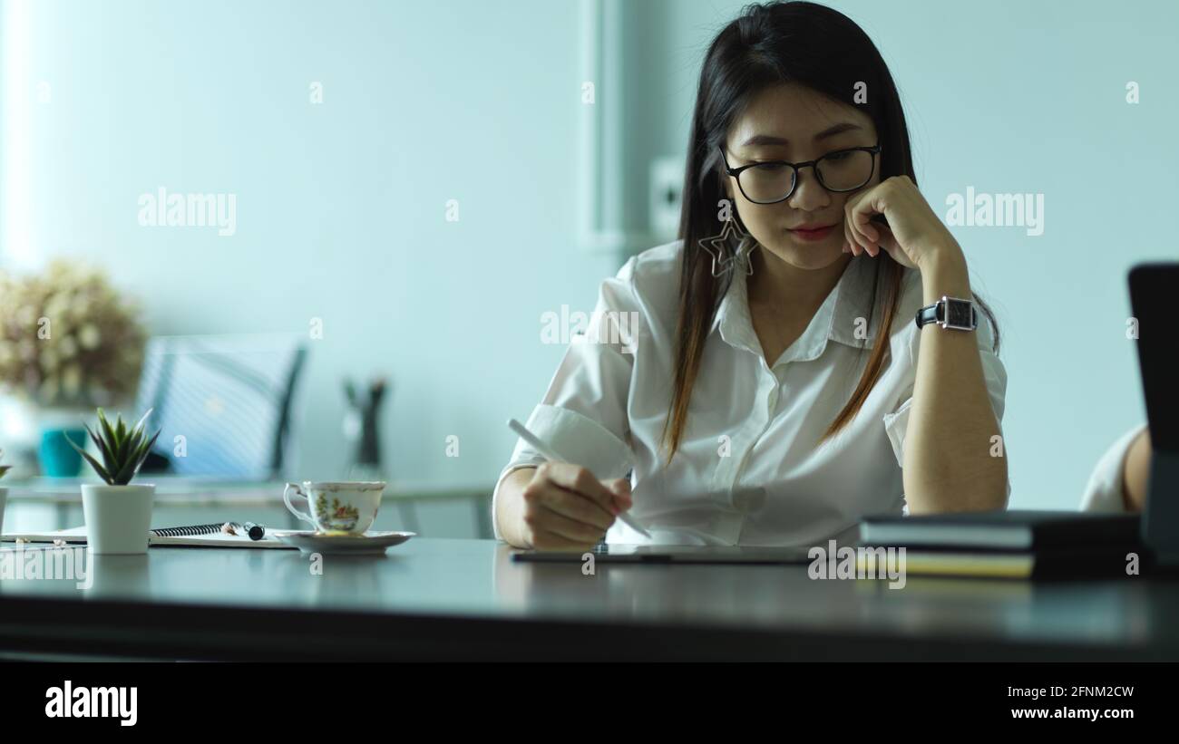 Portrait of female entrepreneur working with office supplies on office ...