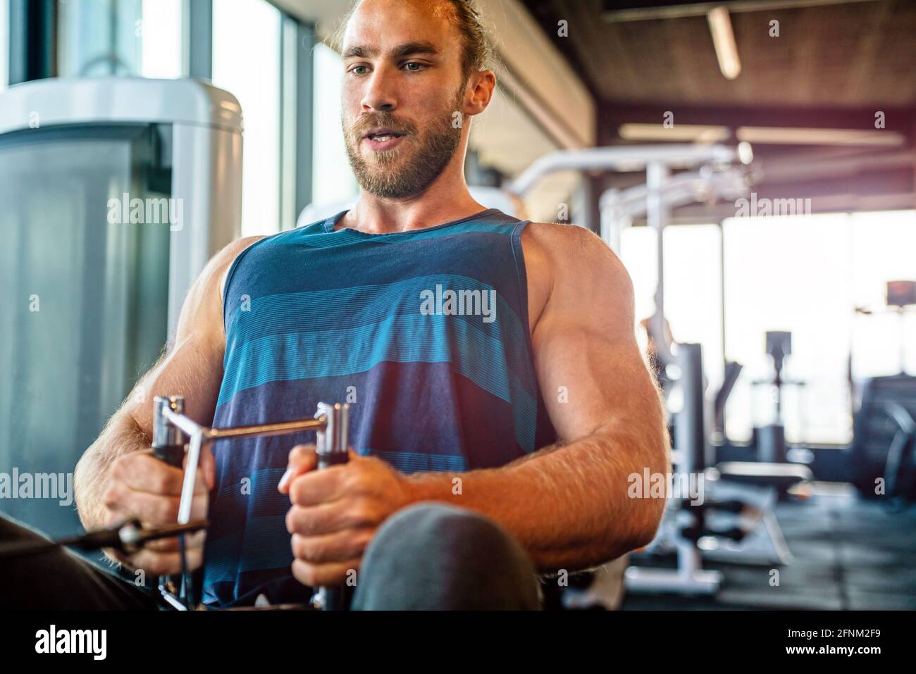 Young muscular man during workout in the gym Stock Photo - Alamy