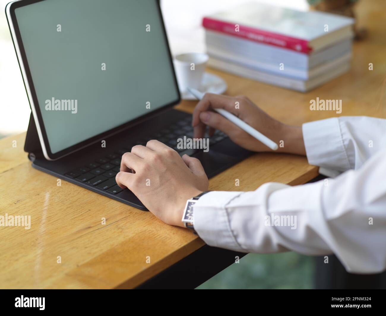 Cropped shot of young female office worker typing on tablet keyboard in ...
