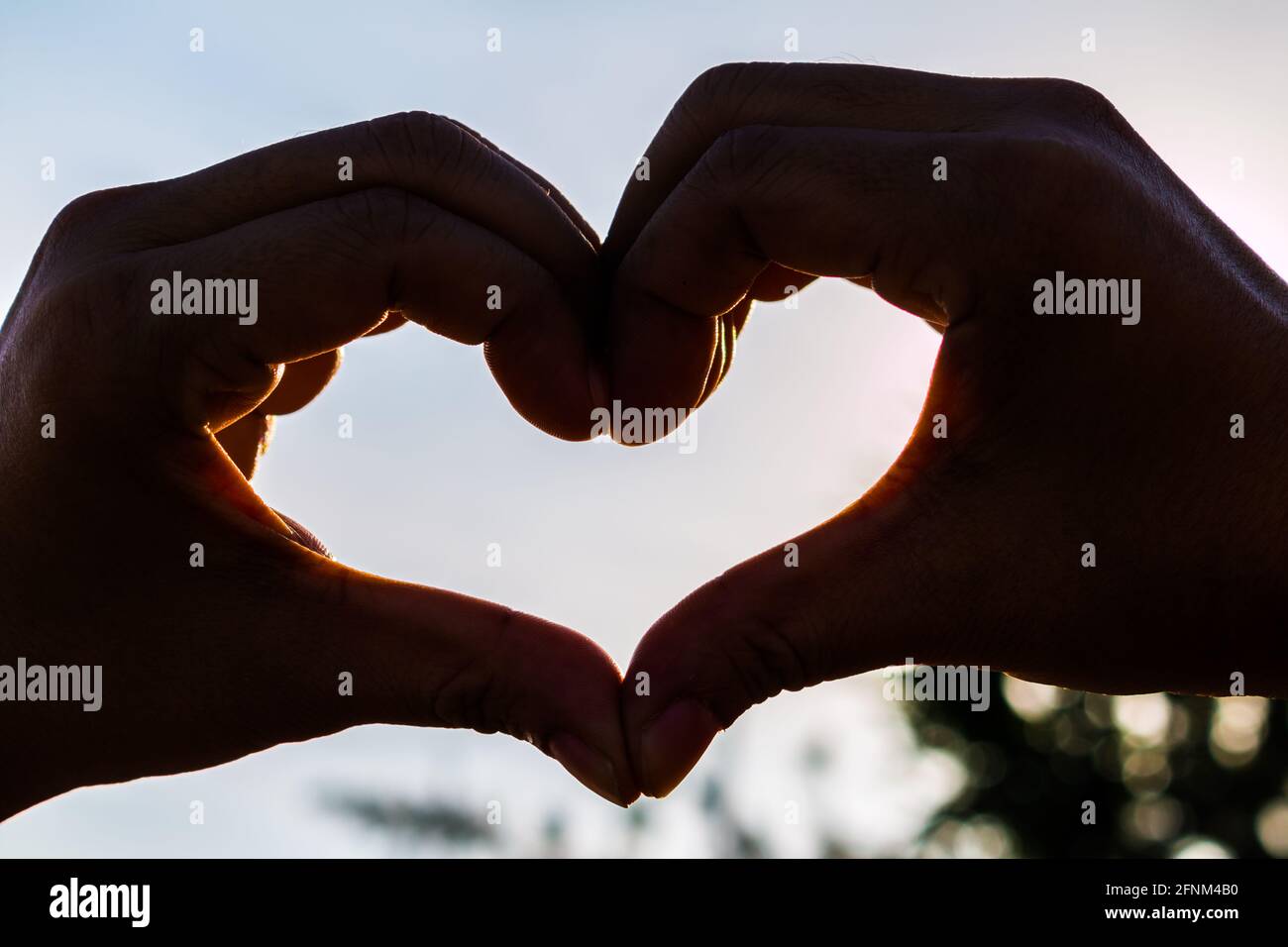 love shape hand silhouette at sunset background Stock Photo - Alamy