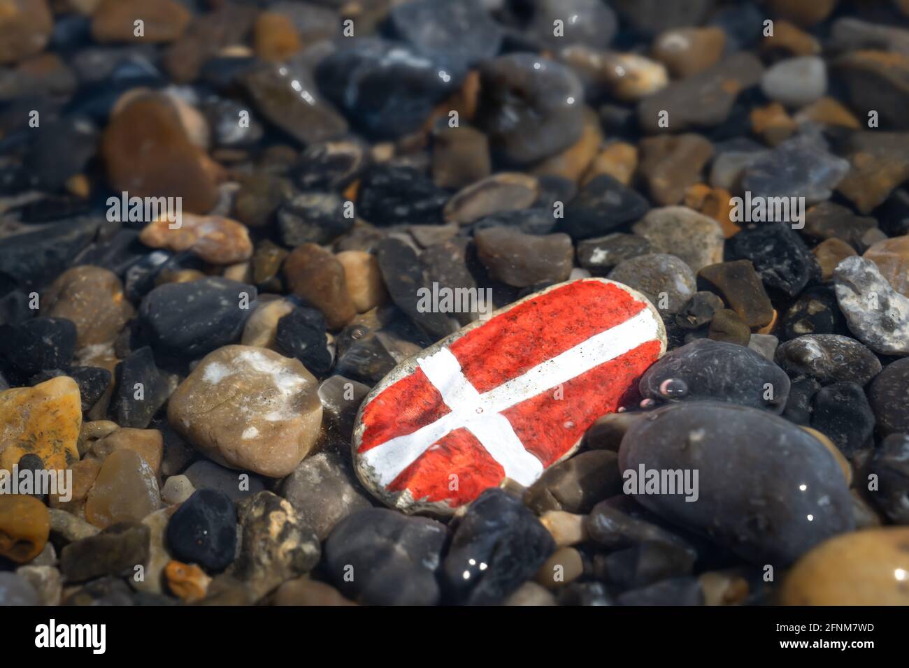 Stone painted with denmark banner at beach in water Stock Photo - Alamy