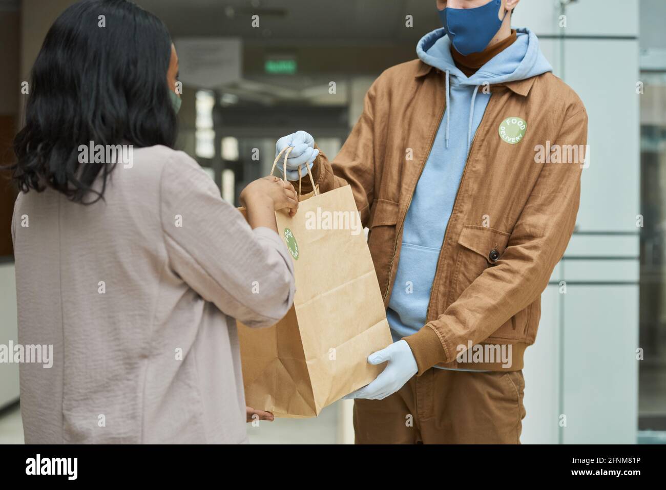 Businesswoman getting packet with food from delivery man at office ...