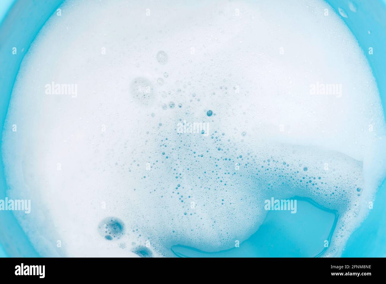 Foam on surface of water in blue plastic basin. Foam as texture or ...