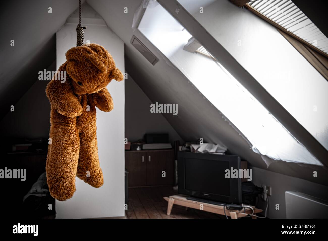 A teddy bear hanging in a noose in the attic room Stock Photo - Alamy