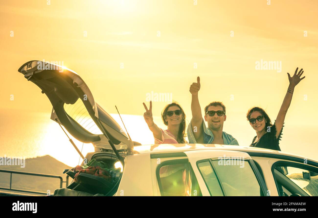 Best friends cheering by car road trip at sunset - Group of happy ...