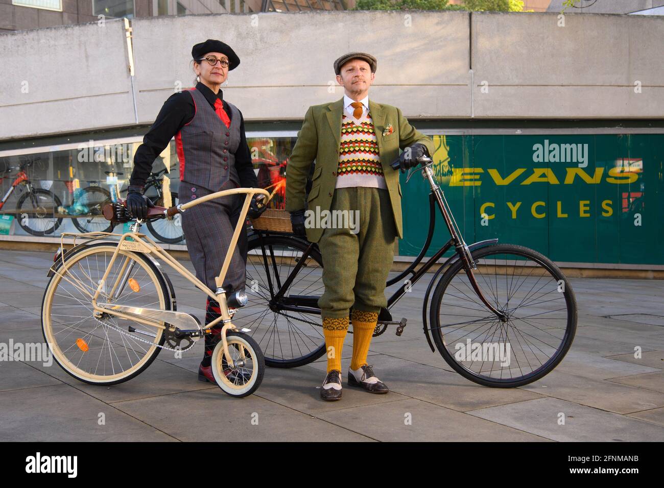 EDITORIAL USE ONLY Cyclists, Russell and Sarah ride bicycles from the 1920s outside the store in ...