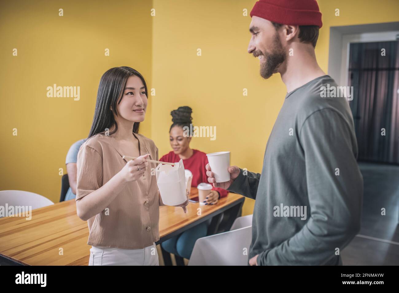 Young colleagues talking while having a coffee break Stock Photo - Alamy