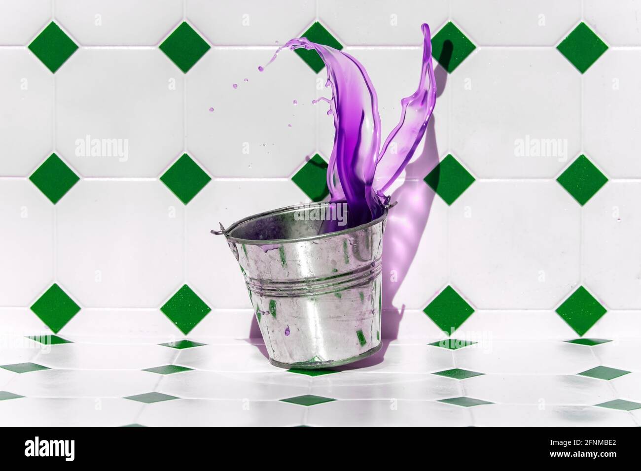 A metal bucket falls to the floor and splashes out the colored liquid ...