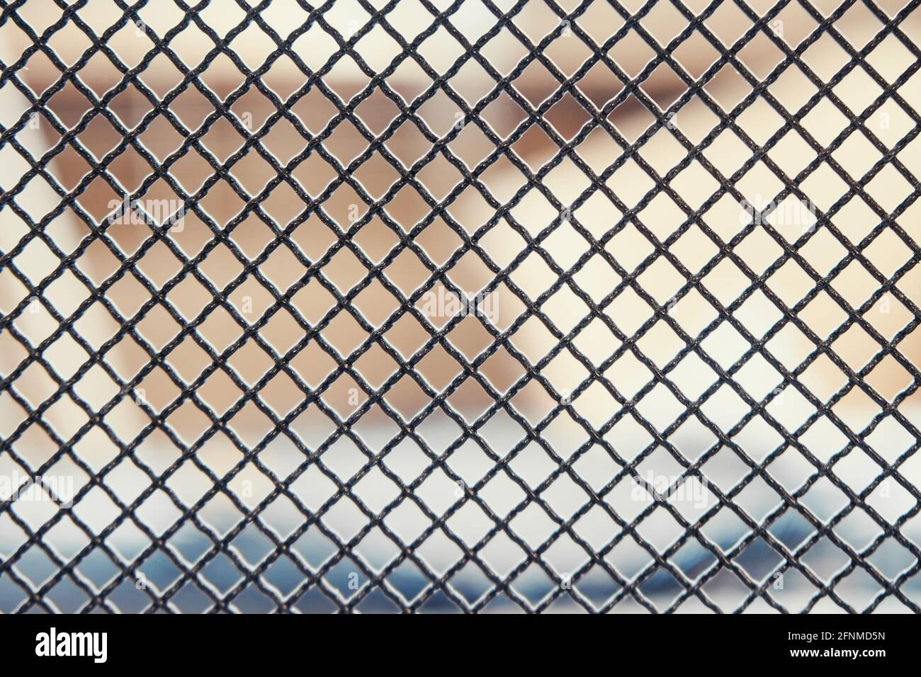 Dark metal fence grid with pattern of numerous small shaped cells ...