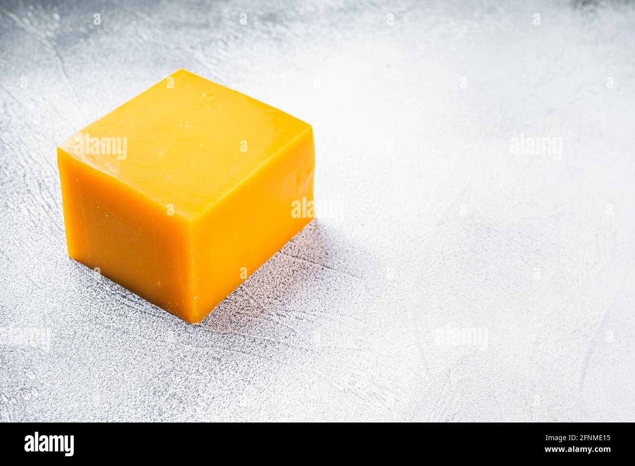 Cheddar Cheese block on a kitchen table. White background. Top view ...