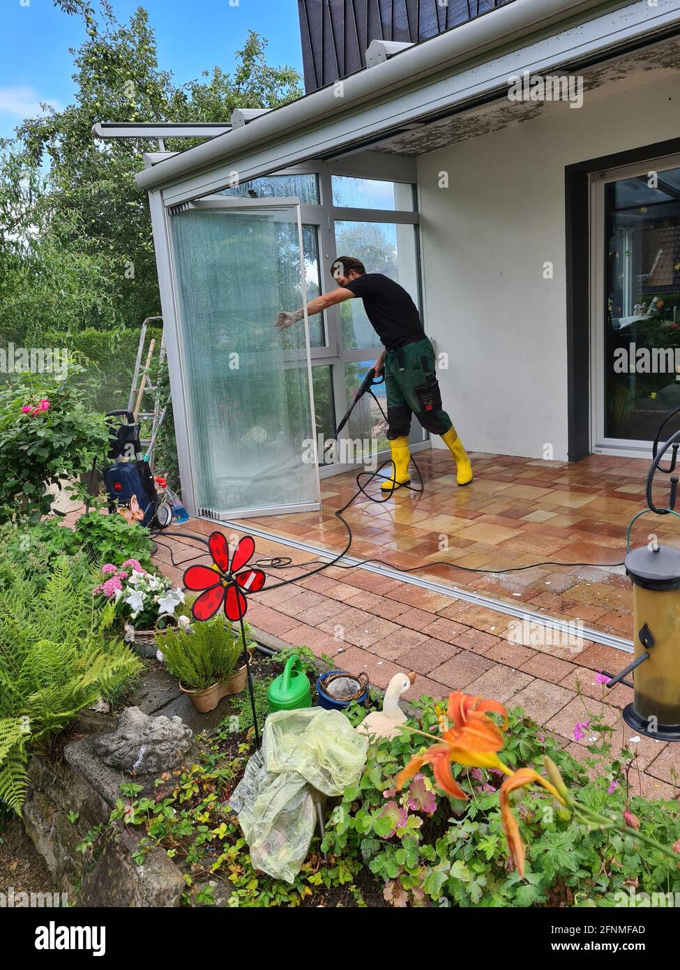 Man cleaning conservatory with a pressure washer - high pressure washer ...