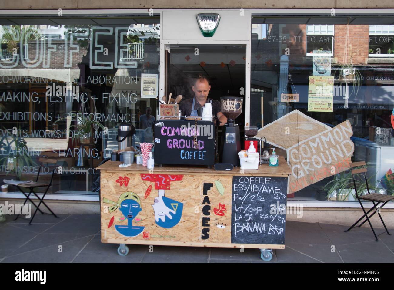 A man serves coffee on the street at his cafe during the Covid-19 ...