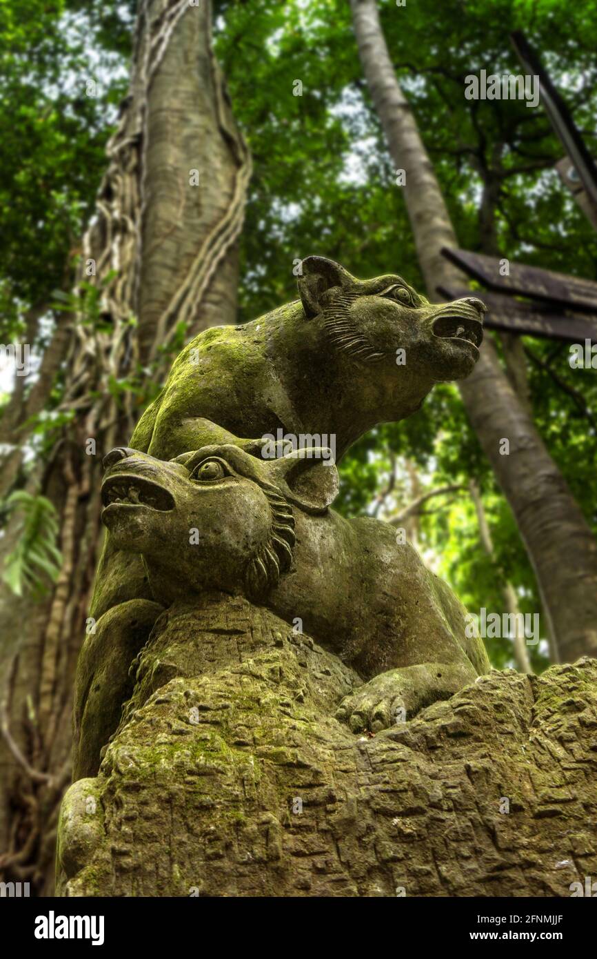 Old stone statue of animals covered in moss Stock Photo - Alamy
