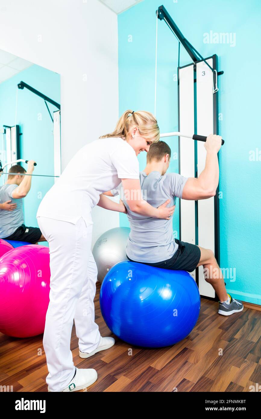 Patient at the physiotherapy doing physical exercises with therapist in ...