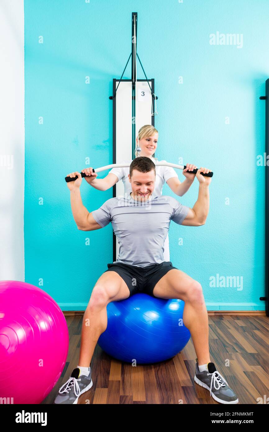 Patient at the physiotherapy doing physical exercises with therapist in ...