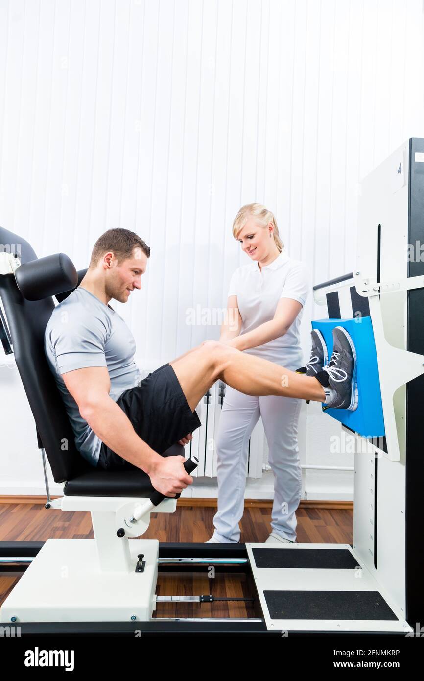 Patient at the physiotherapy doing physical exercises using leg press ...