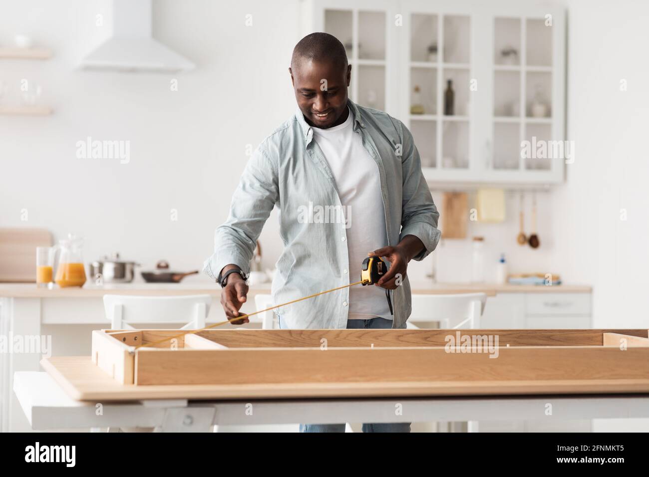Self made modern furniture and hobby. Happy black man measuring table ...