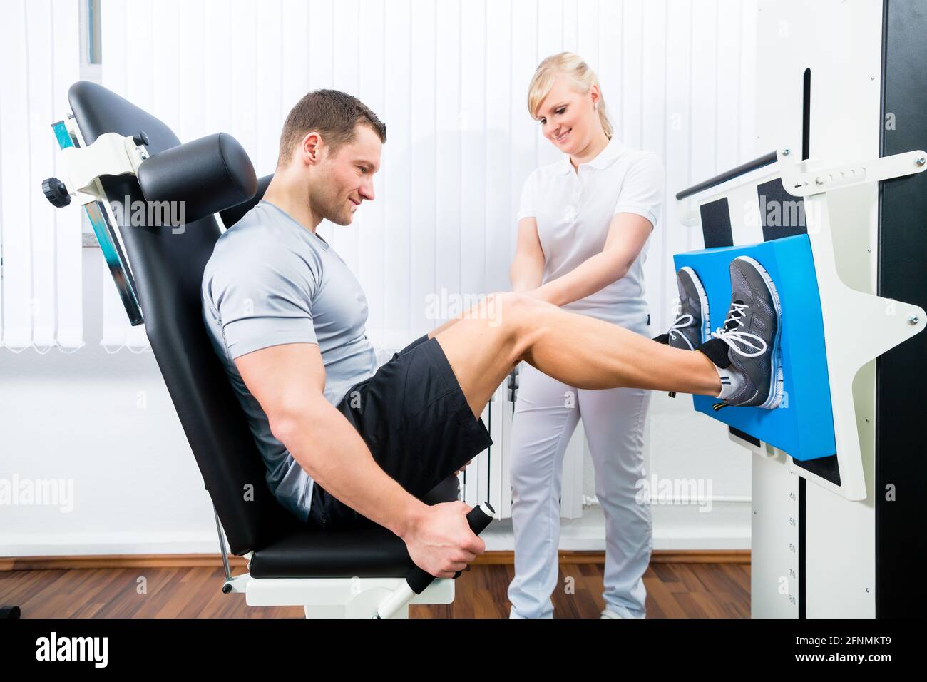 Patient at the physiotherapy doing physical exercises using leg press ...