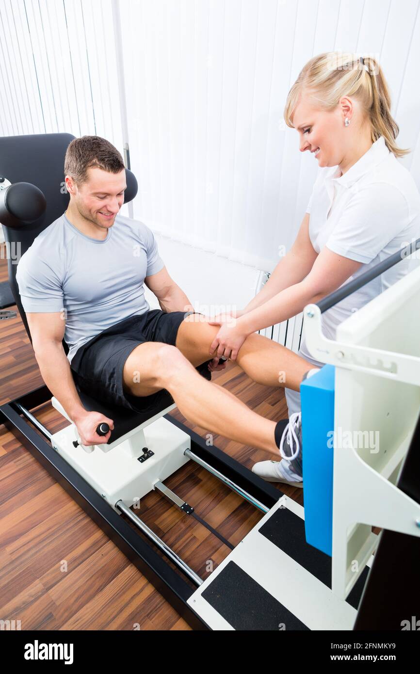 Patient at the physiotherapy doing physical exercises using leg press ...