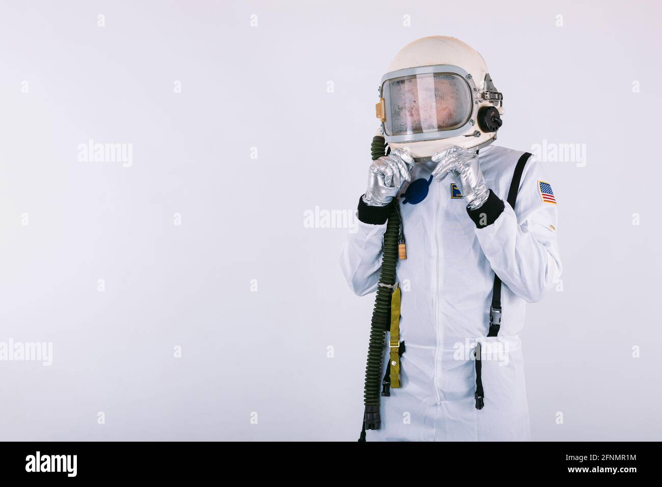 Male cosmonaut in spacesuit and helmet, with surprised face holding the ...