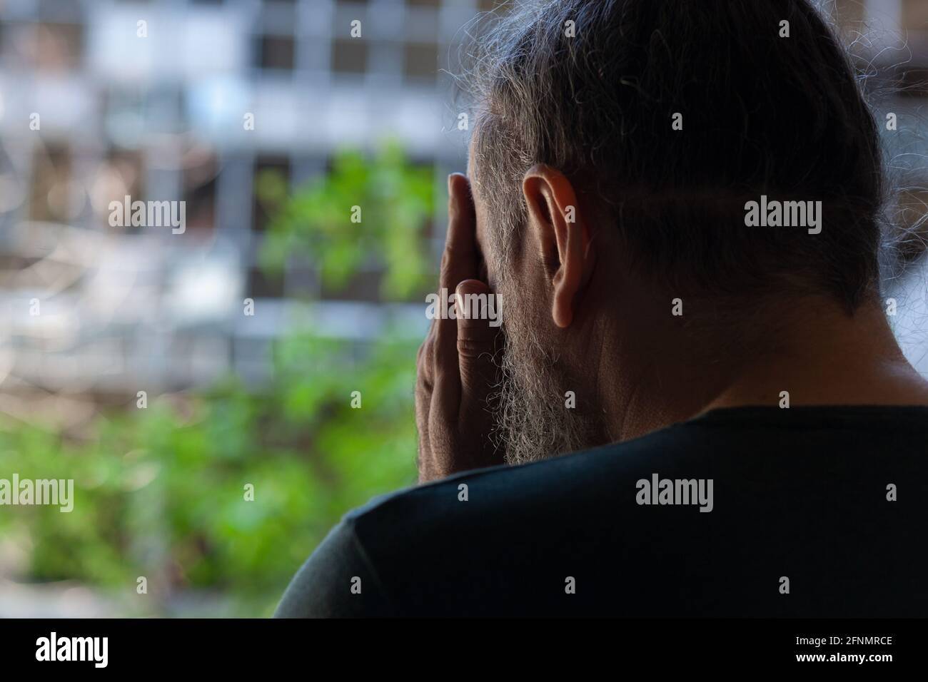 Man with beard standing in front abandoned destroyed building, covering ...