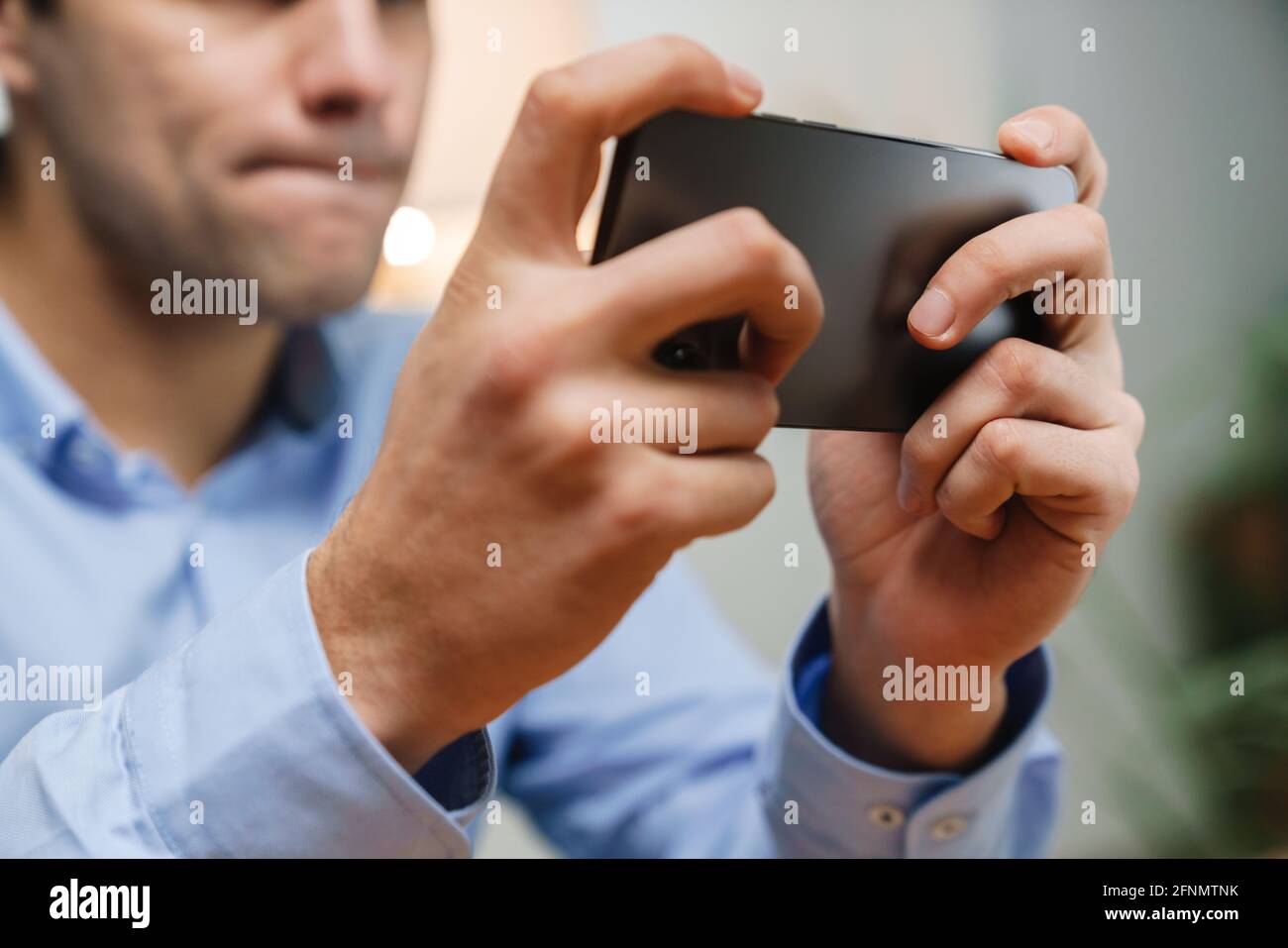Confused frustrated male manager looking at mobile phone while sitting ...