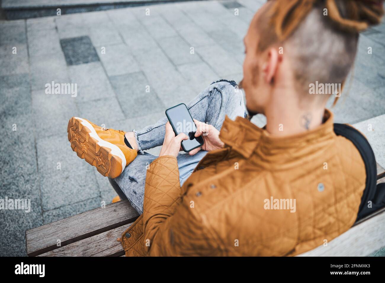 Young person using his modern gadget outdoors Stock Photo - Alamy