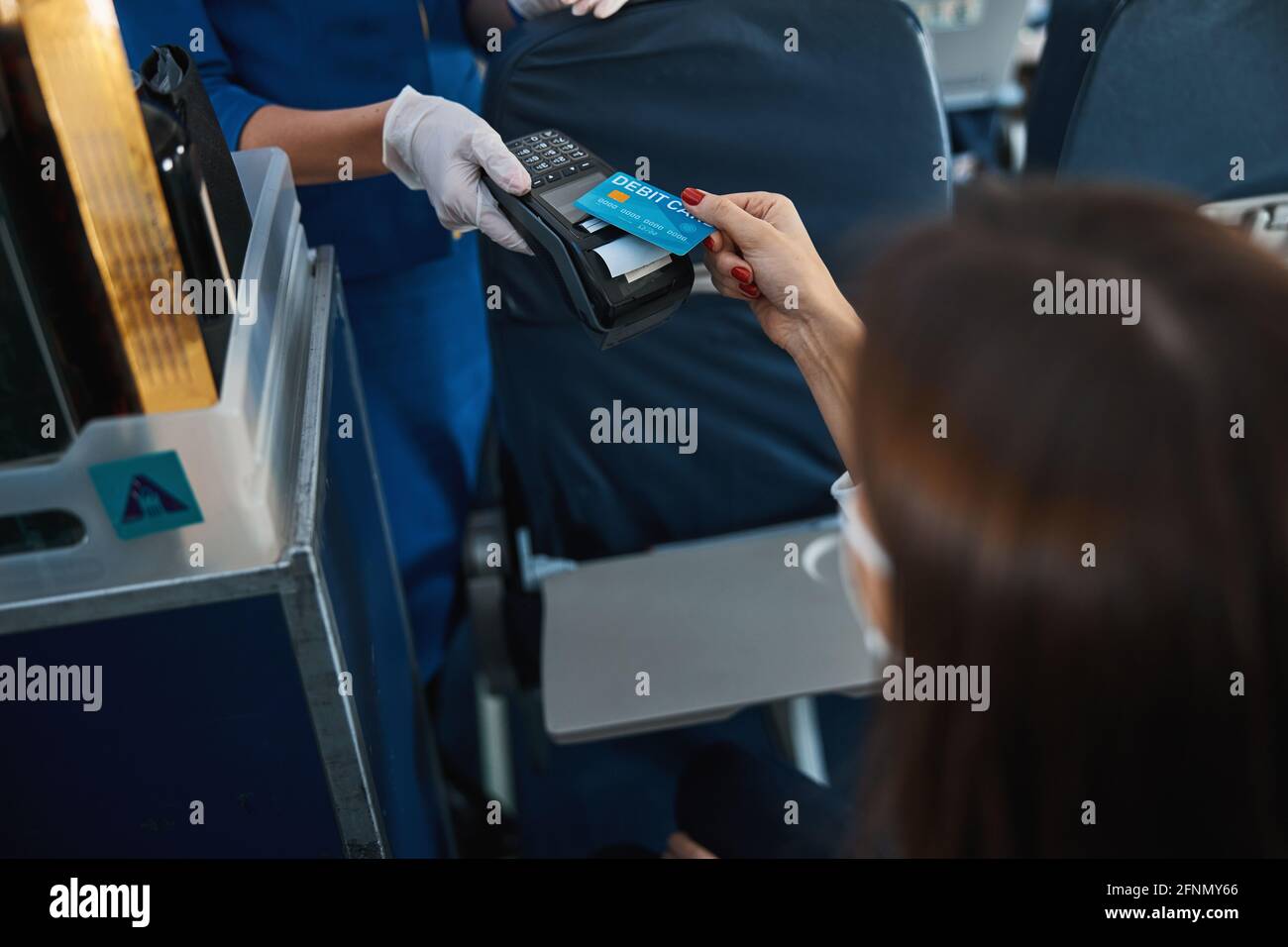 Person on a plane using credit card for payment Stock Photo - Alamy