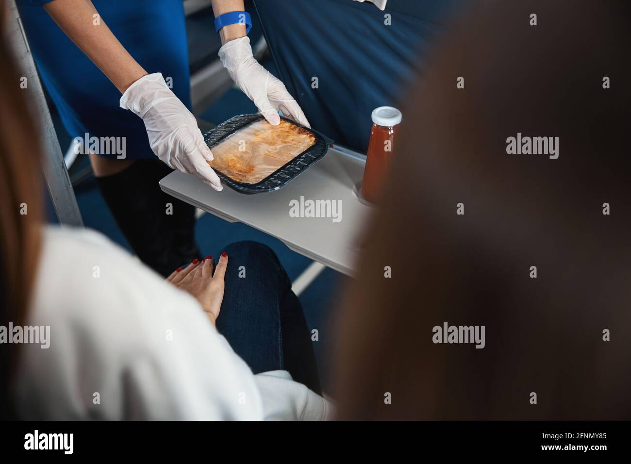 Stewardess placing in-flight meal onto tray table Stock Photo - Alamy